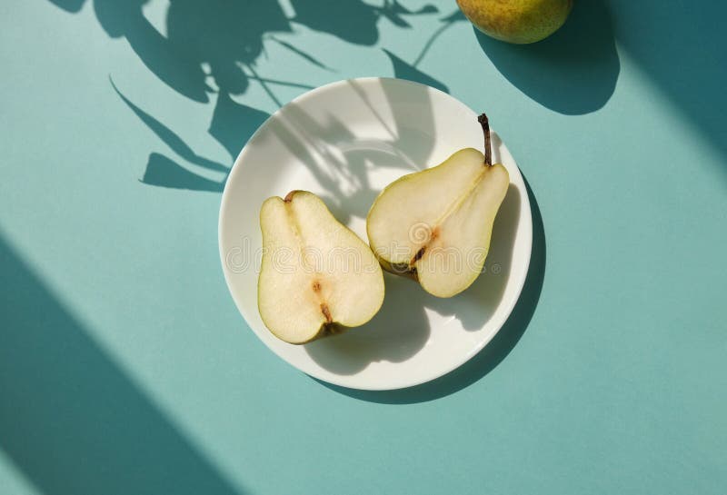 White Plate with Green Pear Half Fruit on the Blue Background. Stock ...