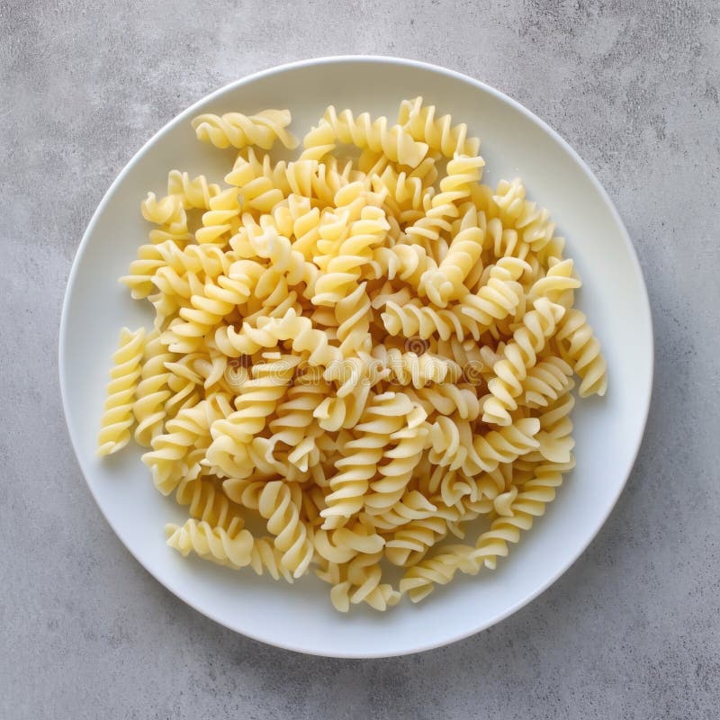 A White Plate Topped with Spirelli Pasta on Top of a Table Stock ...