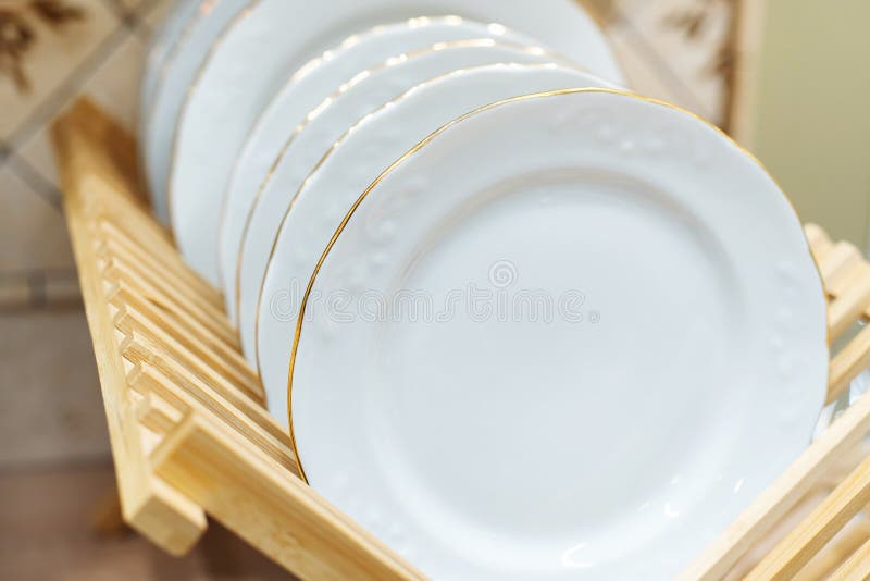 White Plates on a Wooden Stand. Kitchen Utensils Close Up Stock Photo ...