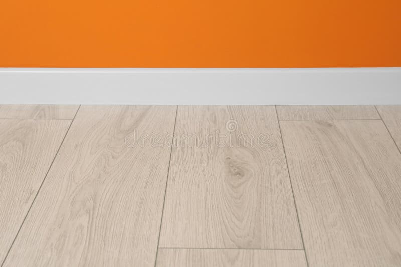 White Plinth on Laminated Floor Near Orange Wall Indoors Stock Image ...