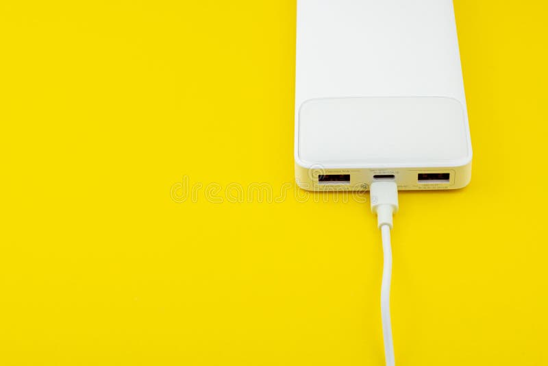 White Power Bank with a USB Cable on a Yellow Surface Stock Image ...