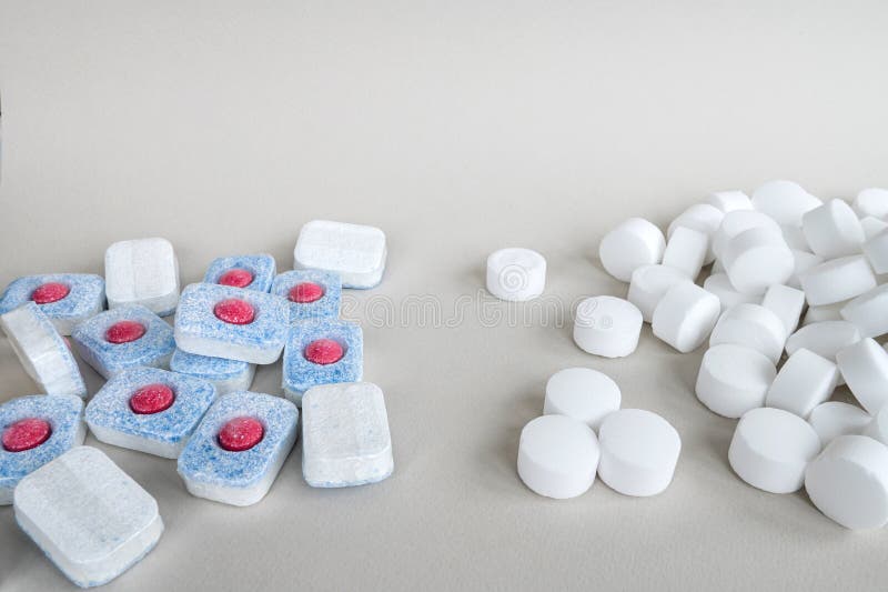 White Pressed Salt Tablets and Colored Dishwasher Capsules Close-up ...