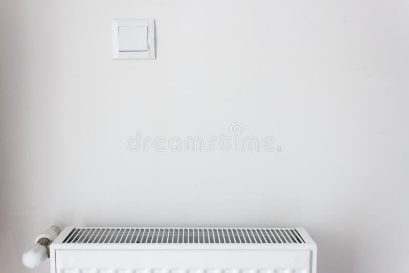 White Radiator on White Wall with Light Switch in Home Indoor Stock ...