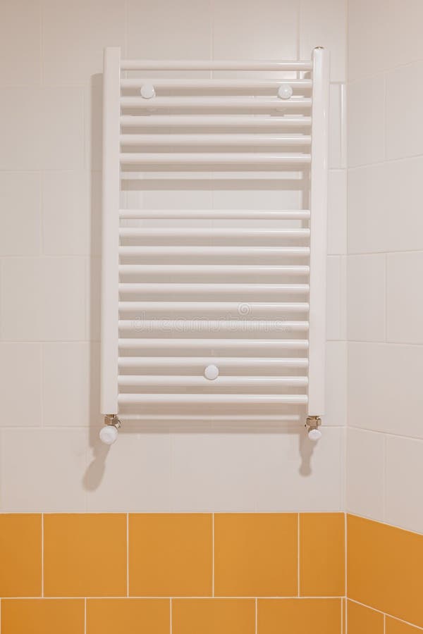 White Radiator on a Yellow and White Tiled Wall in a Modern Bathroom ...