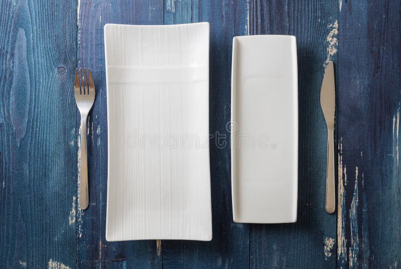 White Rectangular Plates with Fork and Knife on White Wooden Background ...