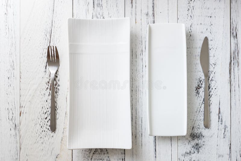 White Rectangular Plates with Fork and Knife on White Wooden Background ...