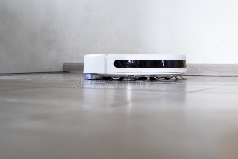 White Robot Vacuum Cleaner Performs Automatic Cleaning in a Bright ...
