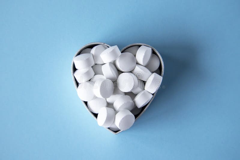 White Round Heart-shaped Tablets on a Blue Background. Stock Photo ...