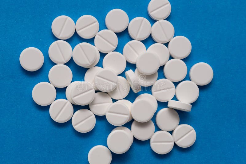 White Round Tablets on a Blue Background. Macro of White Capsules on ...