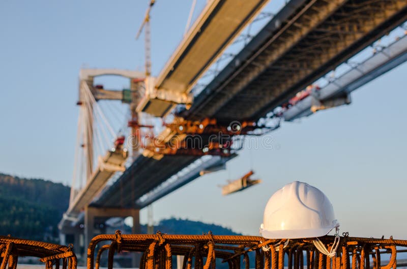 White Safety Helmet on Reinforcing Bars with a Bridge in Construction ...