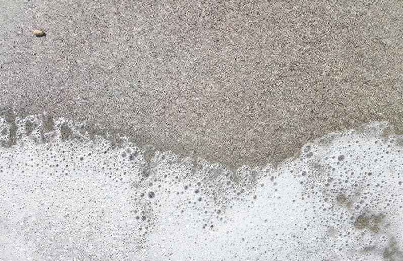 White Sand Texture with Foamy Spray from the Sea and One Little Pebble ...