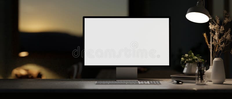 A White-screen Computer Mockup and a Dim Light from a Lamp on a Table ...