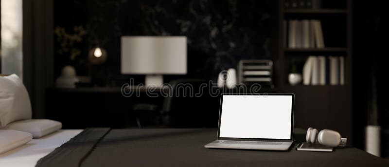 A White-screen Laptop Computer, a Book, and a Headphone on a Bed in a ...