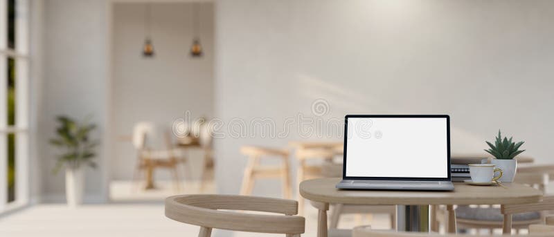 A White-screen Laptop Computer Mockup on a Table in a Spacious ...