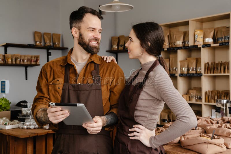 White Sellers Man and Woman Smiling and Using Tablet Computer in Eco ...