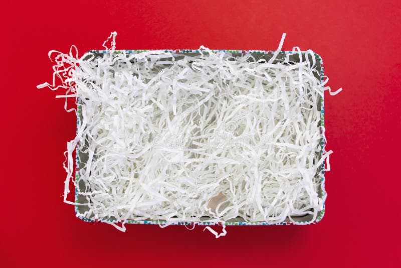 White Shredded Paper Packaging Material in Box Flat Lay on Red ...