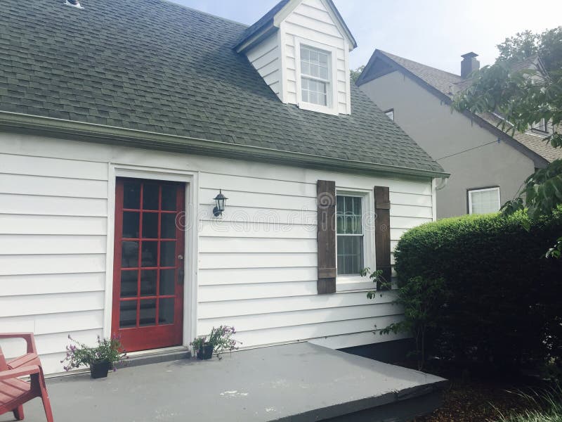 Cape Cod House with Red Door Stock Photo - Image of siding, white ...