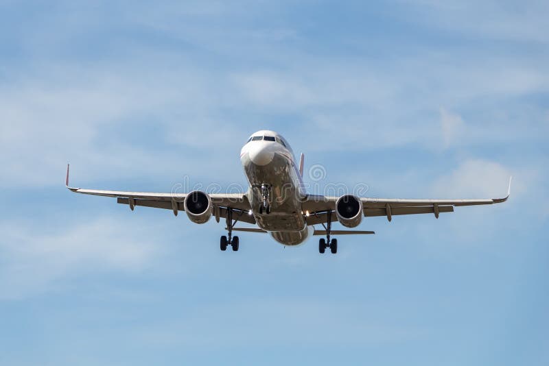 White and Silver Plane with Chassis is Landing on the Blue Sky with ...