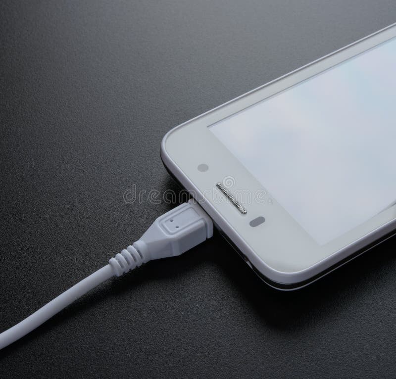 White Smart Phone Charging with USB Cable on Black Table Stock Image ...