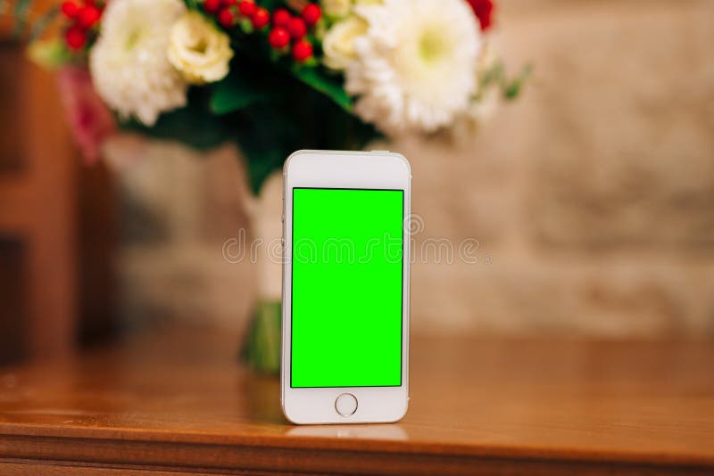 A White Smartphone with a Green Screen, and a Bridal Bouquet of Stock ...