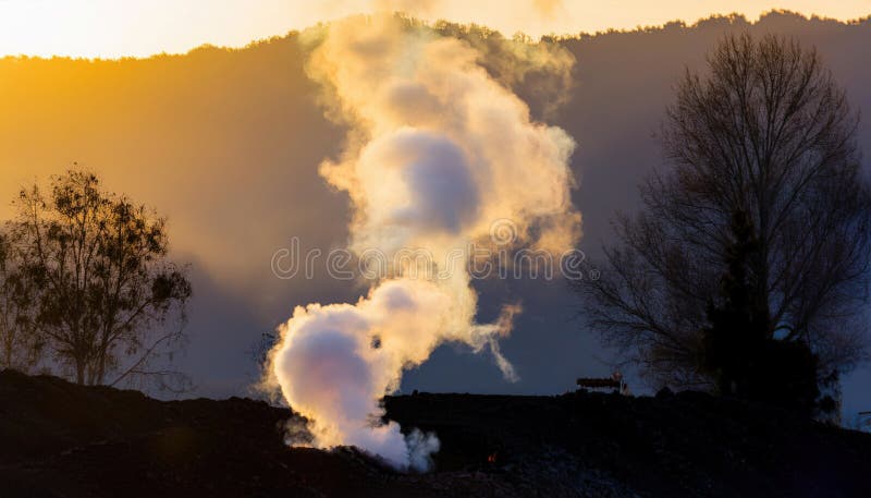 White Smoke Billows Dramatically Against a Glowing Sunset in a Serene ...