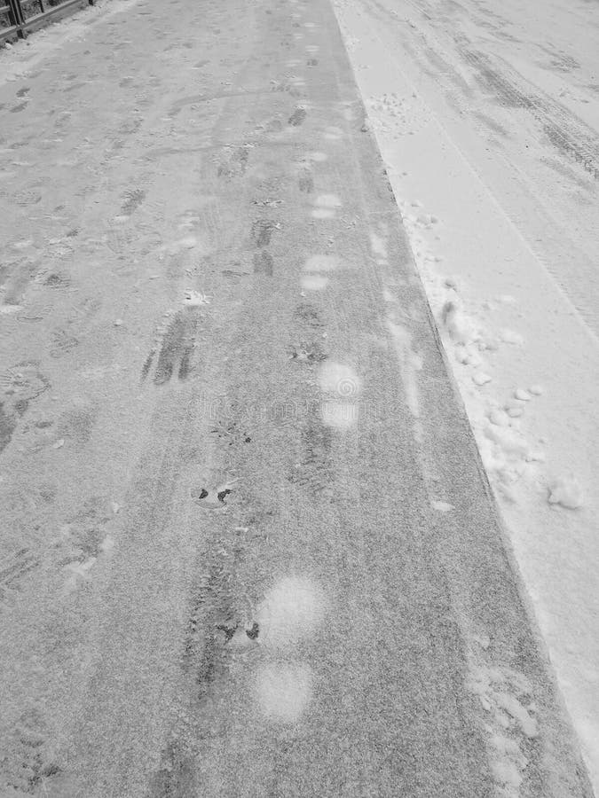 White Snowy Footprints on Grey Asphalt Pavement Covered with Fresh Snow ...