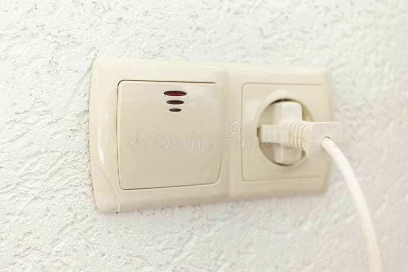 White Socket with Plug and Light Switch on an Empty Wall with Space for ...