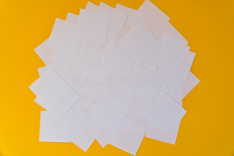 White Square Paper Pieces Spread Out in Chaotic Order on a Yellow ...