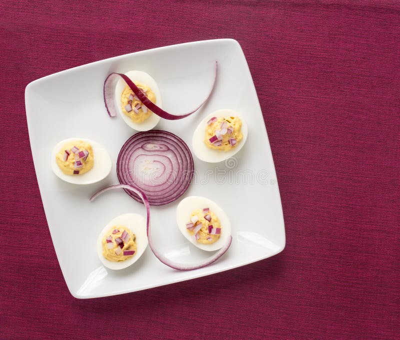 Red Onion Deviled Eggs on Maroon Background, Close Up Stock Photo ...