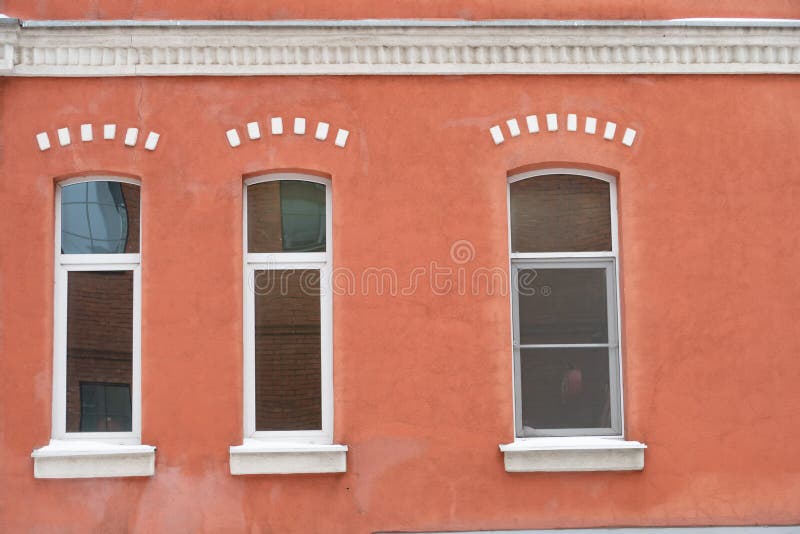 White Stone Cornice and Three Narrow White Windows on a Reddish ...