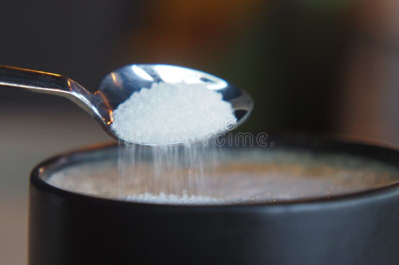 White Sugar Pouring from a in a Paper Packet on a Coffee Cup Stock ...
