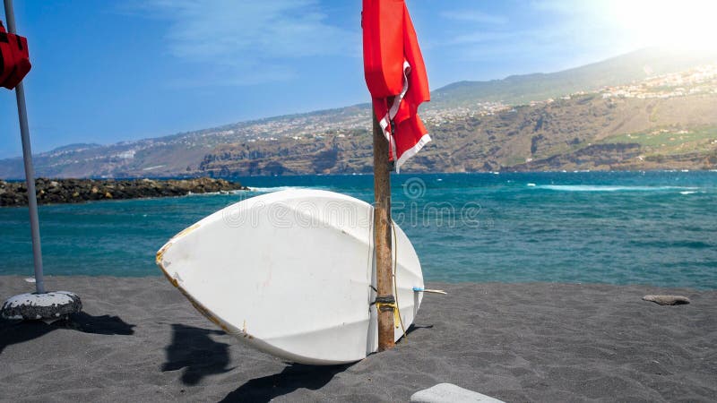 White Surfboard and Lifeguard Post on the Ocean Beach Wth Black ...