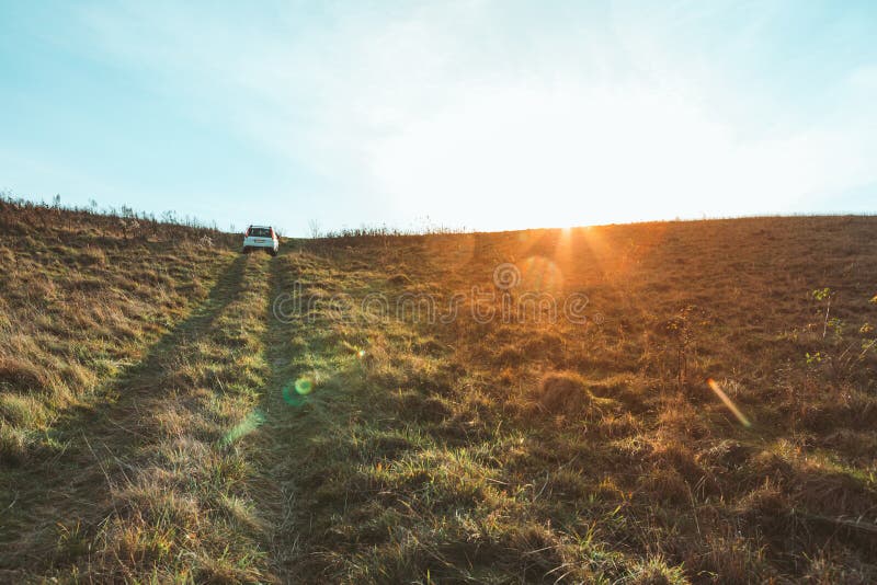 White Suv Car Riding by Trail Road at the Field on Sunset Stock Photo ...