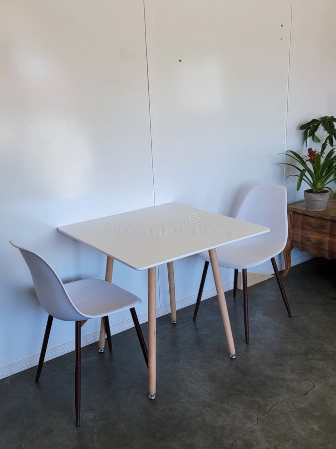 White Table and Chairs Setup Dark Floor White Wall Stock Image - Image ...