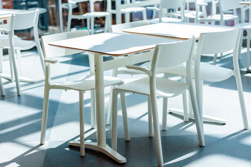 White Tables and Square-shaped Chairs in the Lighted Dining Room. Close ...