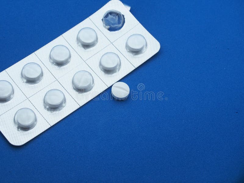 White Tablets on a Blue Background. One Tablet without Packaging, the ...