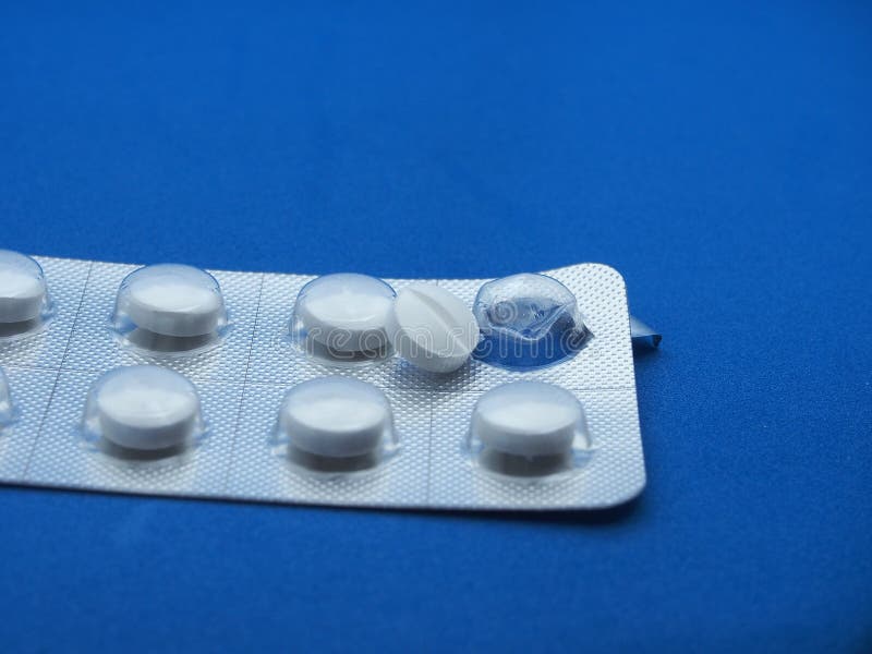 White Tablets on a Blue Background. One Tablet without Packaging, the ...