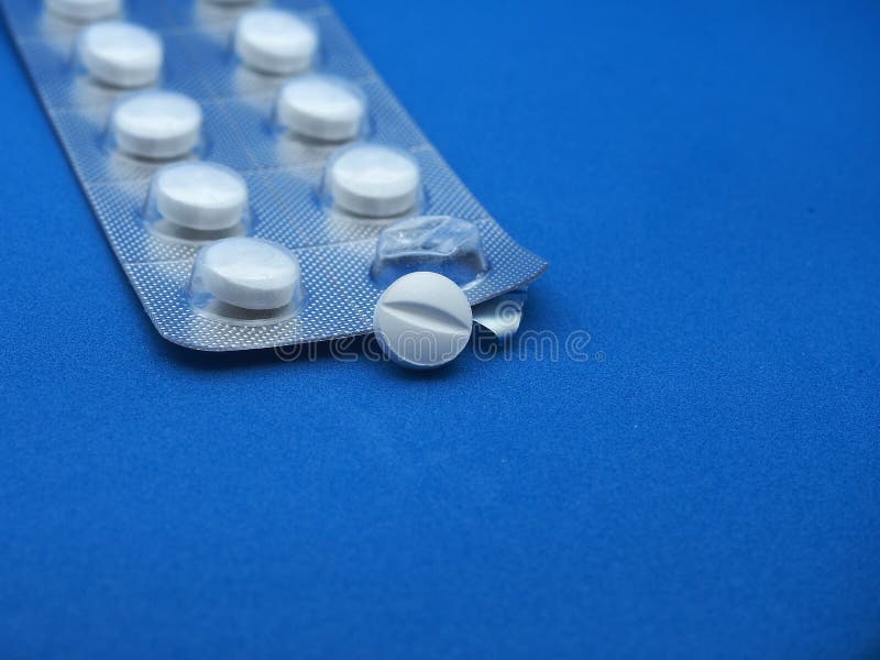 White Tablets on a Blue Background. One Tablet without Packaging, the ...