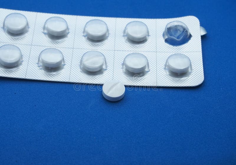 White Tablets on a Blue Background. One Tablet without Packaging, the ...