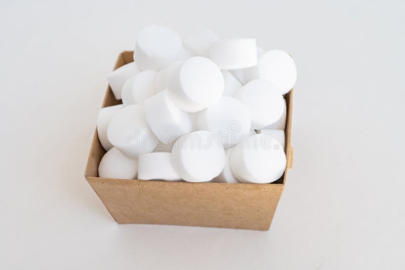 White Pressed Salt Tablets for the Dishwasher Close-up in a Box. Place ...