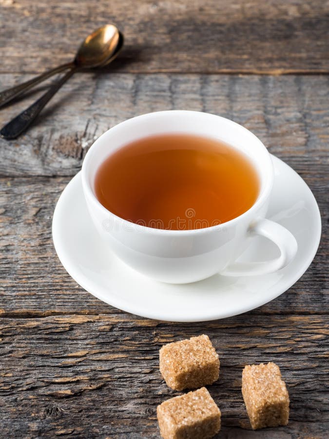 White Tea Cup and Saucer Brown Cane Sugar on a Rustic Wooden Background ...