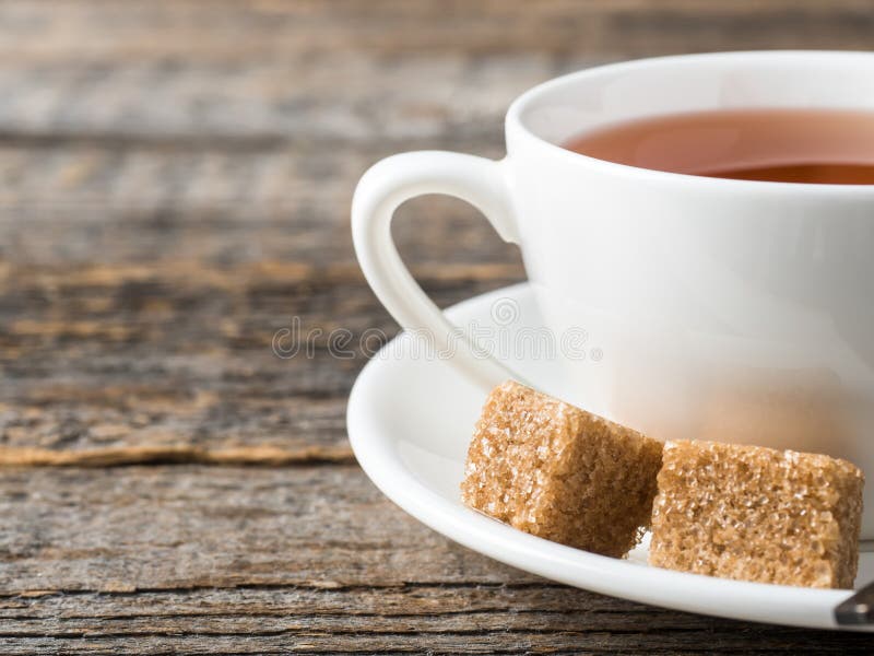 White Tea Cup and Saucer Brown Cane Sugar on a Rustic Wooden Background ...