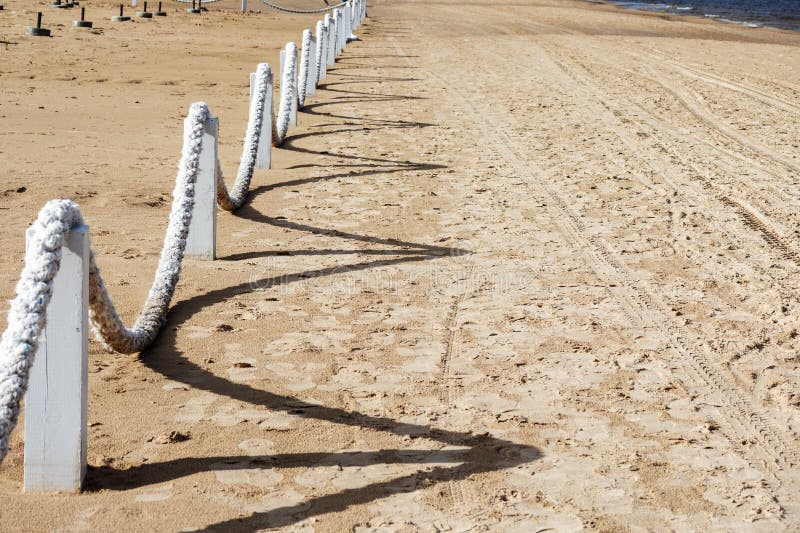 A White and Thick Rope Hangs in an Arc Form on Wooden Poles in the Sea ...