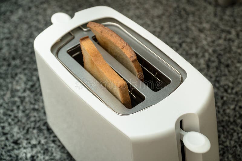 White Toaster with Toasted Bread for Breakfast Inside. Gray Table Stock ...