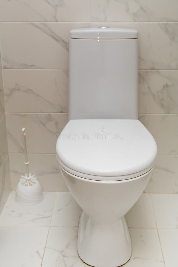 White Toilet Against a White Wall in the Bathroom Stock Image - Image ...