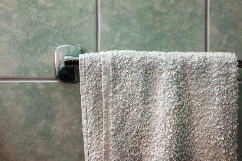 A White Towel on a Holder in Front of a Green Tile Wall Stock Photo ...