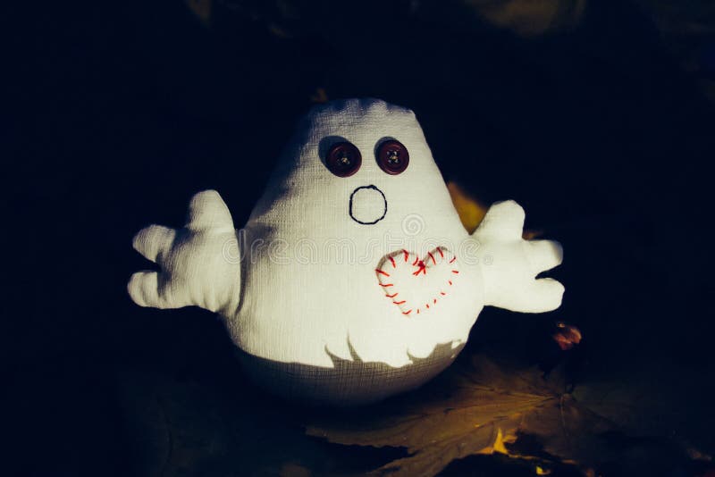 A White Toy Monster with Button Eyes Sits in the Dark Stock Image ...