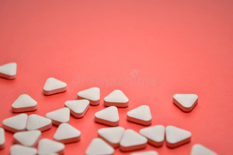 Pink Triangular Unusual Pills in a White Round Box on a Yellow ...