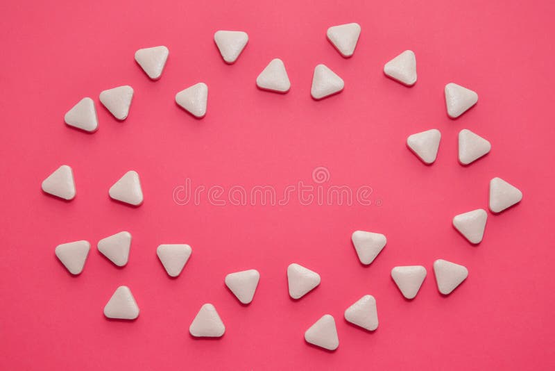 Pink Triangular Unusual Pills in a White Round Box on a Yellow ...