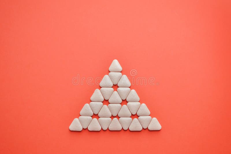 Pink Triangular Unusual Pills in a White Round Box on a Yellow ...